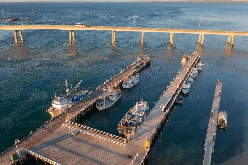 Image of Aerial view of fishing boats docked alongside jettys near a ...