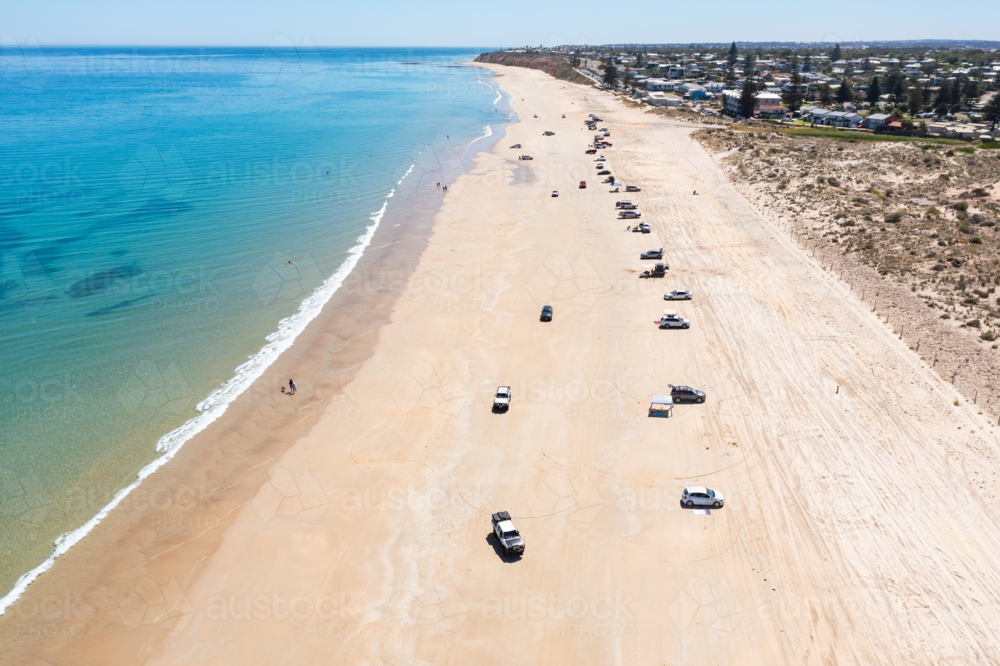 Image of Aerial view of four wheel drives lined up on a sandy beach ...