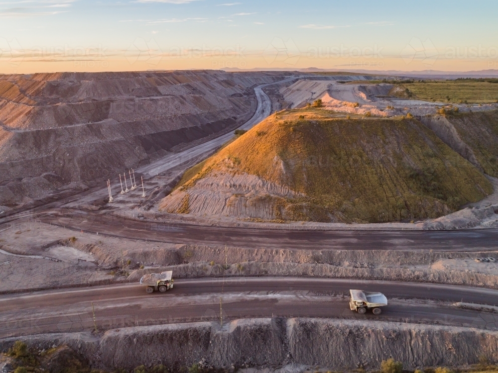 Image of Aerial view of full and empty dump trucks passing one another ...