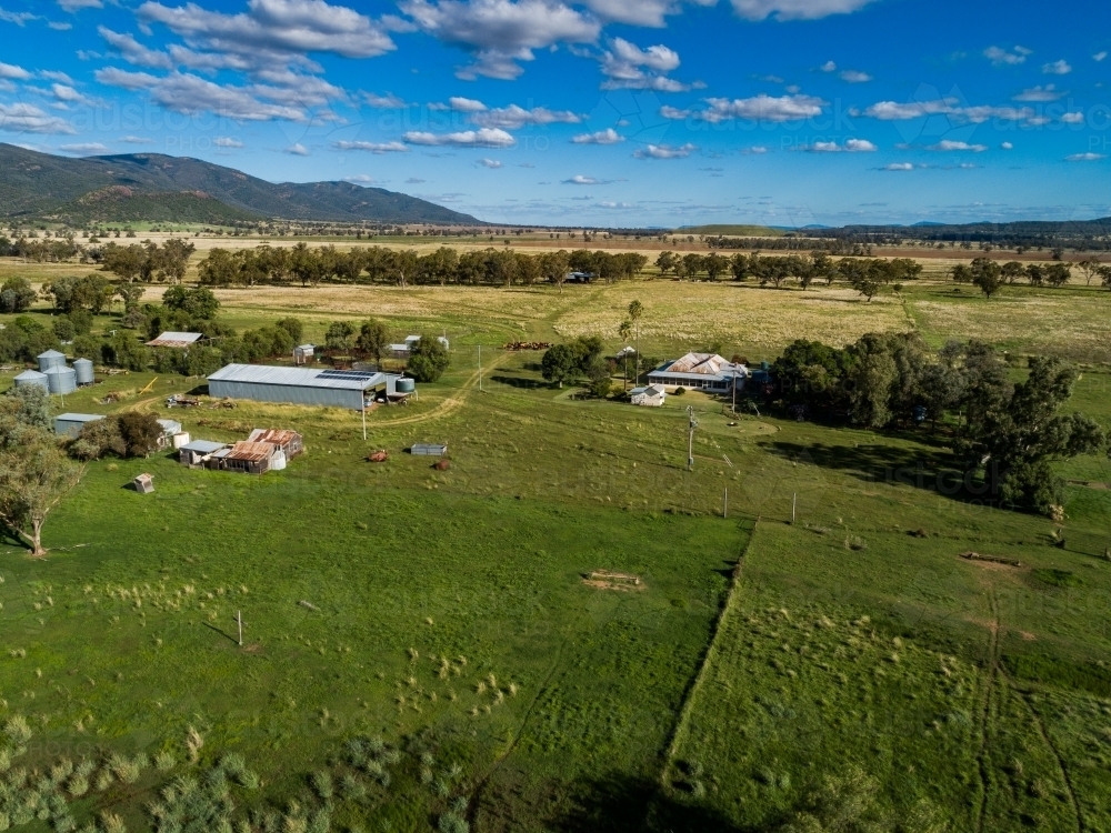 Image of Aerial view of green farm paddock and farm shed beside ...
