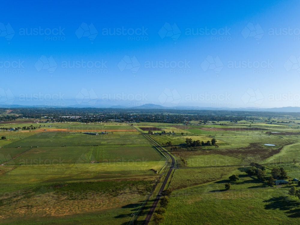 Image of Aerial view of green farmland paddocks on bright sunlit summer ...