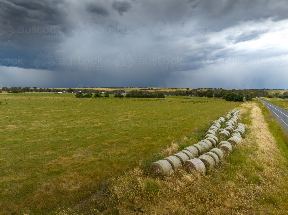 Image of Aerial view of hay bales alongside a farm paddock with rain ...