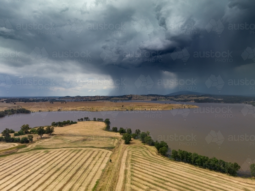 Image of Aerial view of heavy rain falling from storm clouds over a ...
