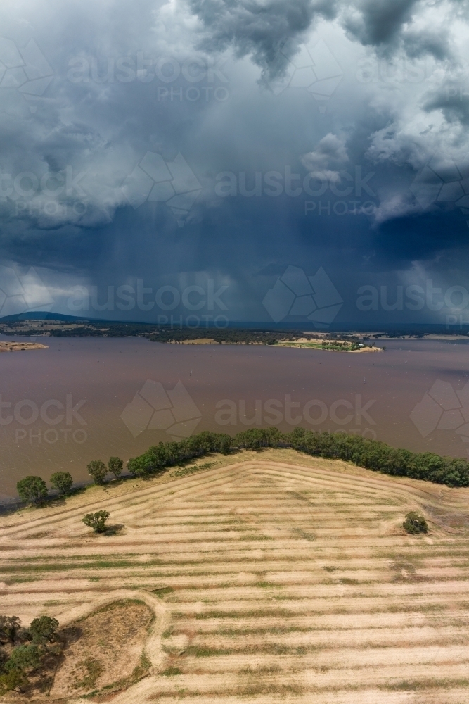 Image of Aerial view of heavy rain falling from storm clouds over a ...