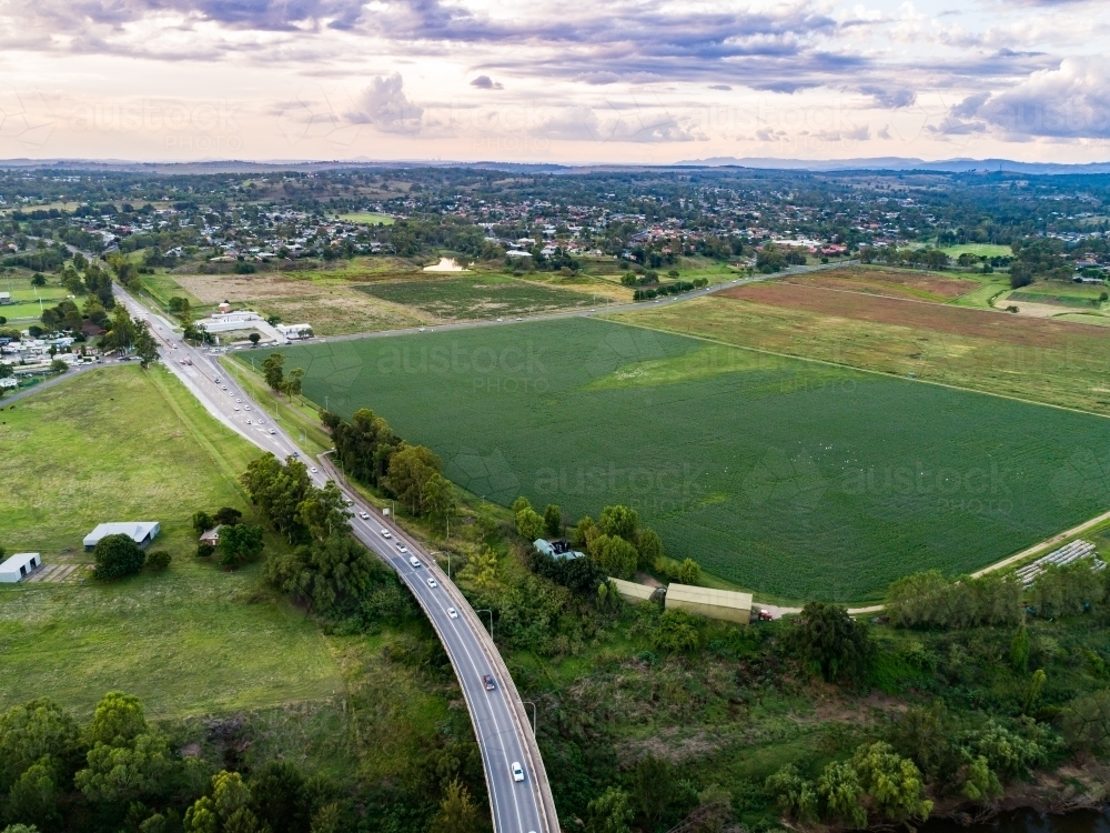 Image of Aerial view of highway beside green paddock of alfalfa lucerne ...