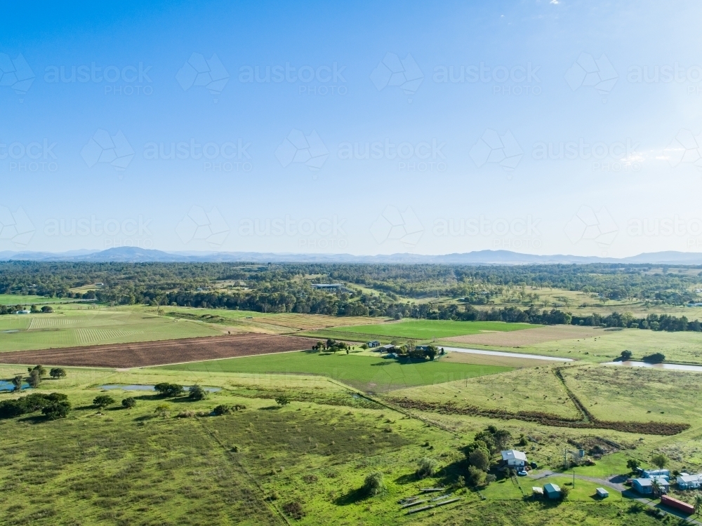 Image of aerial view of little houses on farms with dam and patchwork ...