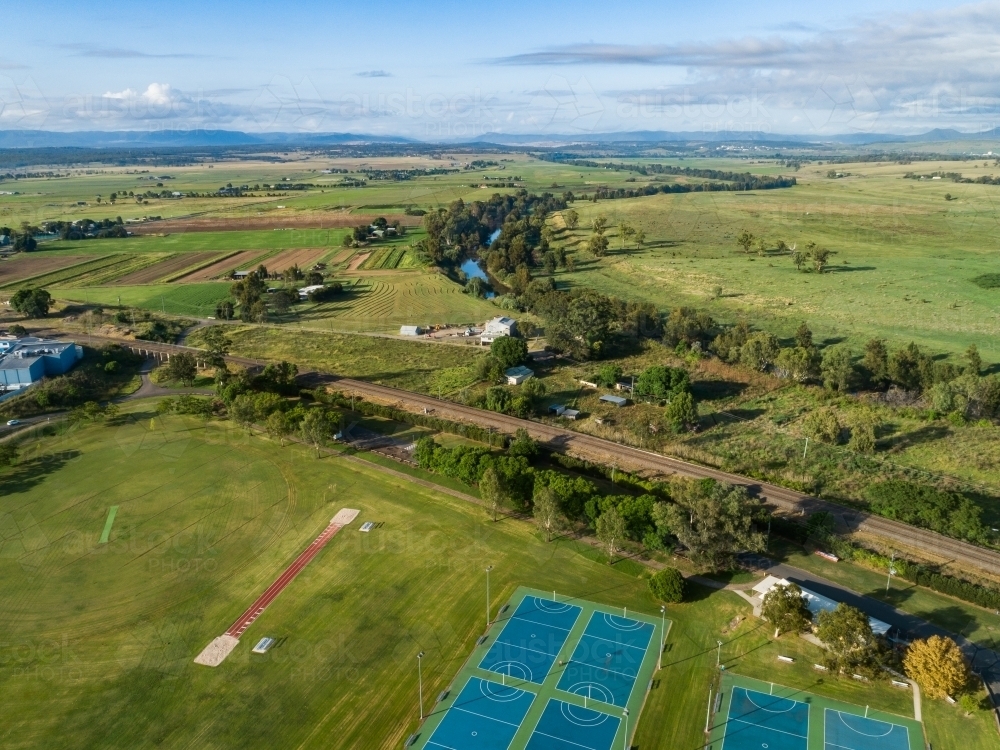 Image of Aerial view of long jump track and pit and netball court with ...