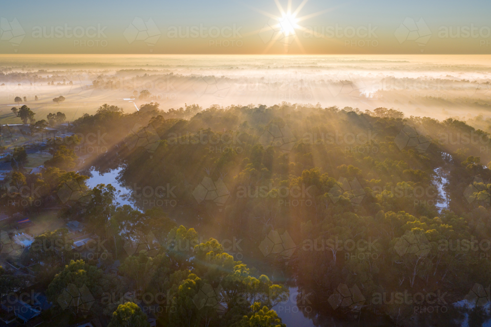 Image of Aerial view of morning sunshine through thin fog over bushland ...