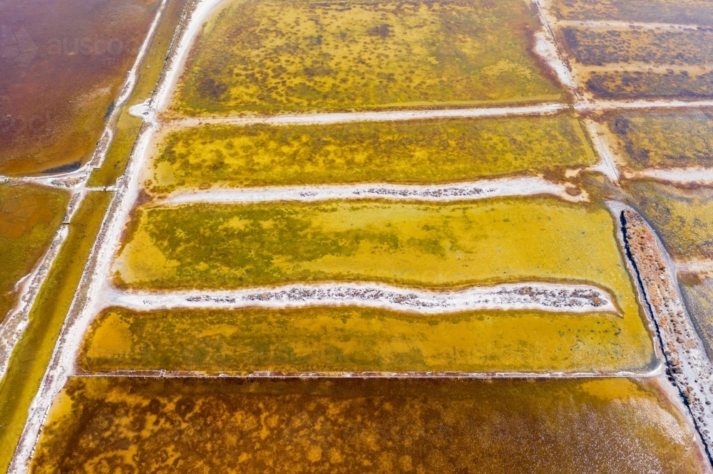 Image of Aerial view of multi-colored salt pans at a commercial ...