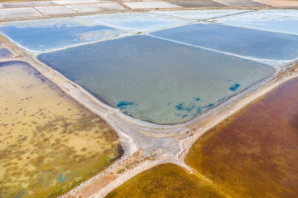 Image of Aerial view of multi-colored salt pans at a commercial ...