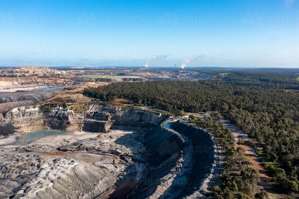 Image of aerial view of open cut coal mine in forested area - Austockphoto