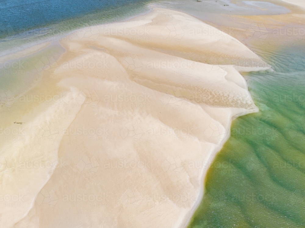 Image of Aerial view of patterns in white sand bars surrounded by blue ...