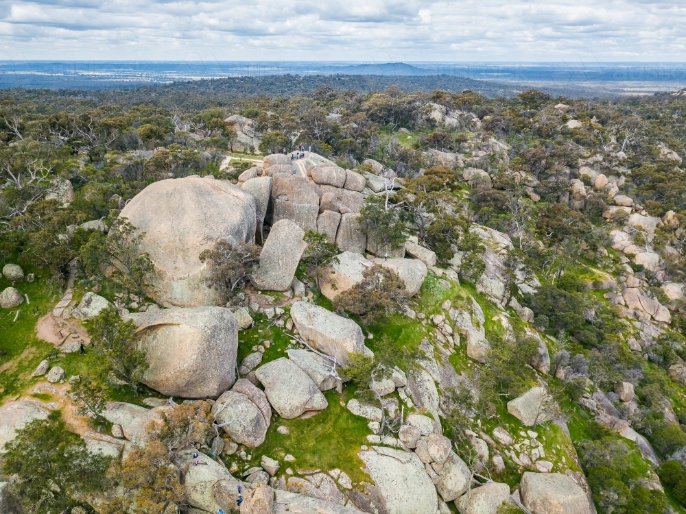 Image of Aerial view of people climbing on large granite boulders on a ...