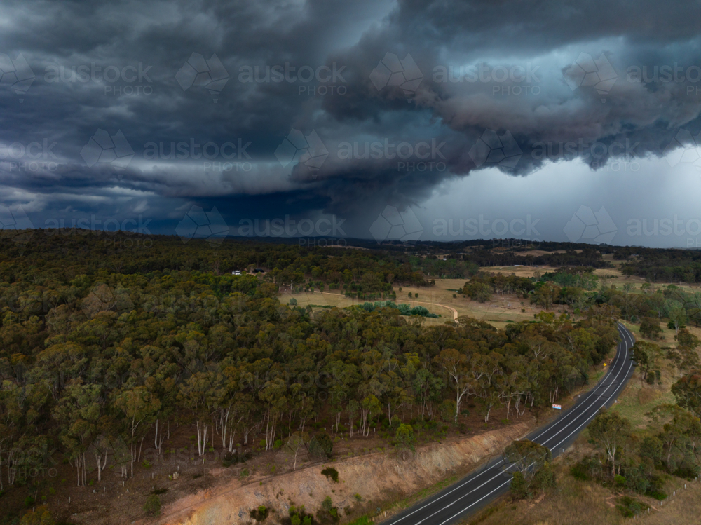 Image of Aerial view of rain falling from dark storm clouds over a ...