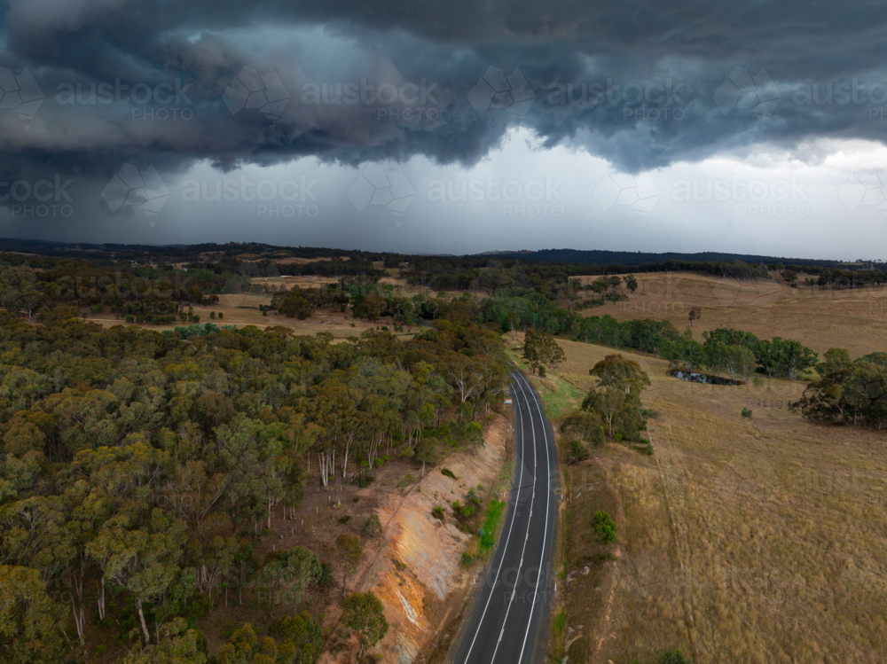 Image of Aerial view of rain falling from dark storm clouds over a ...