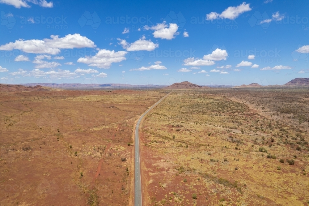Image of Aerial view of remote asphalt road that curves in the distance ...