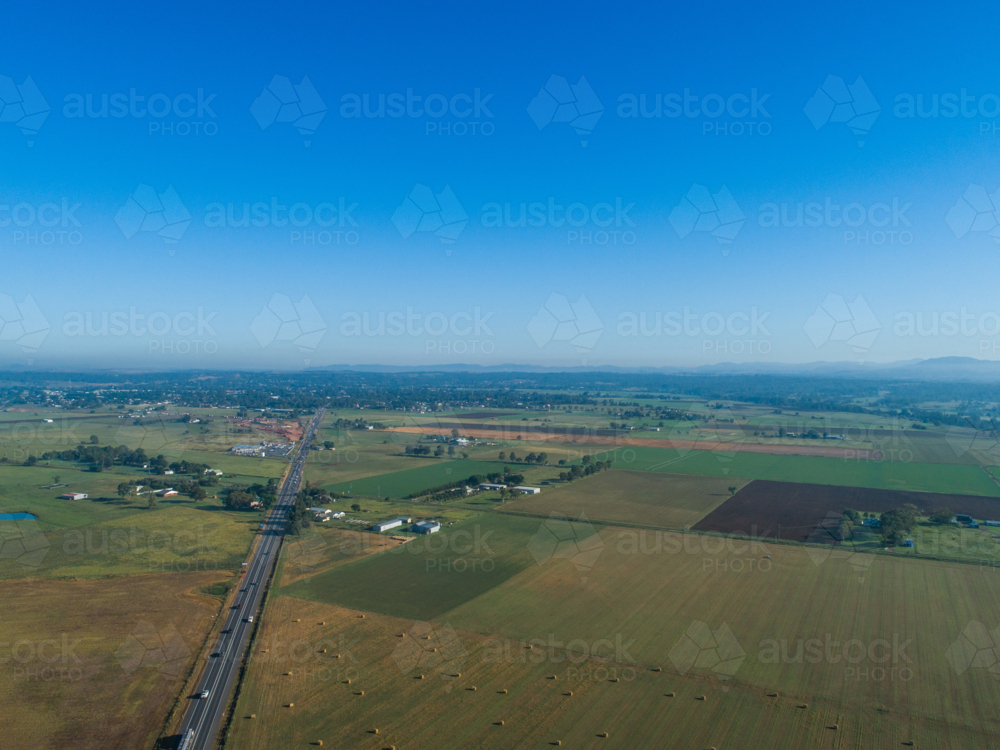 Image of Aerial view of road through paddocks of crops in flat ...