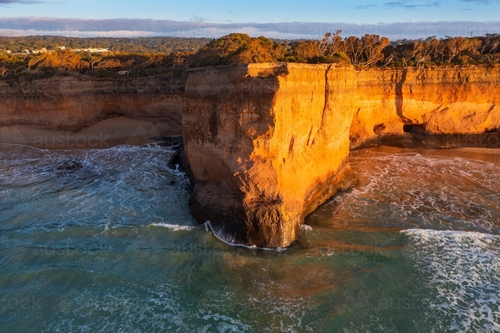 Image of Aerial view of rugged coastal cliffs catching golden dawn side ...