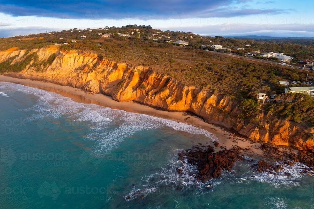 Image of Aerial view of rugged sea cliffs in golden morning sunshine ...