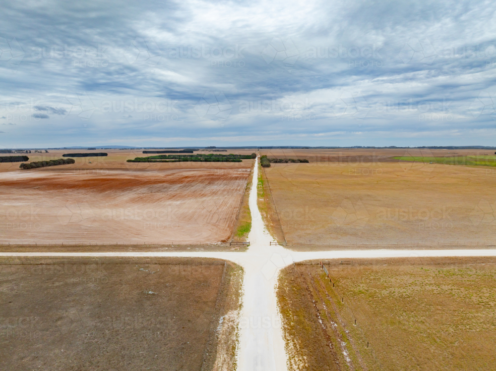 Image of Aerial view of rural crossroad with barren paddocks alongside ...
