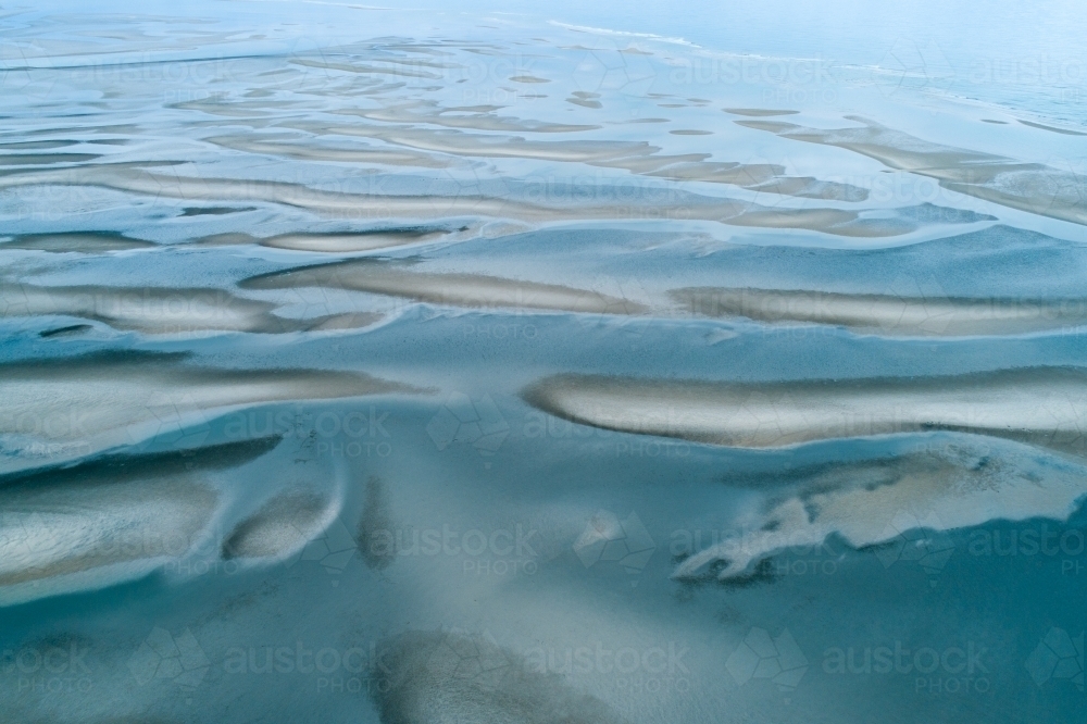 Image of Aerial view of sandbar patterns in shallow blue water ...