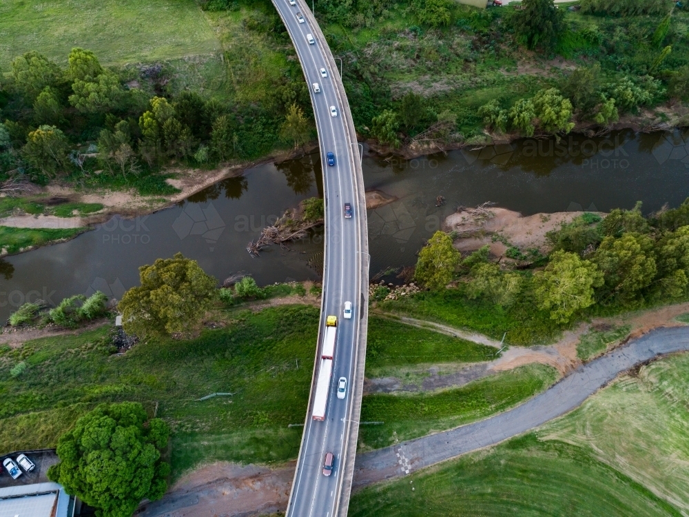 Image of Aerial view of semi truck and cars driving over bridge ...