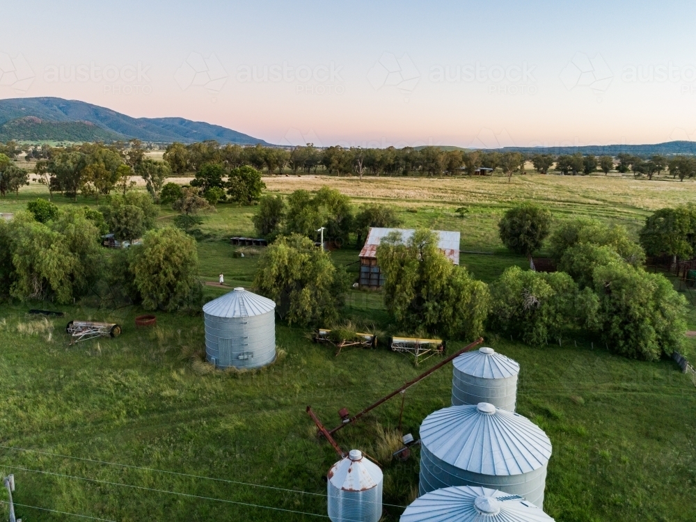 Image of Aerial view of silos on farm at dusk - Austockphoto