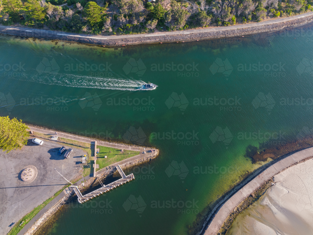 Image of Aerial view of small boat travelling past a fork in a coastal ...