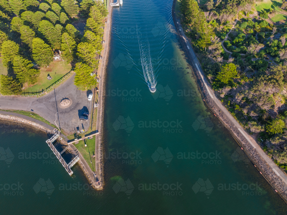 Image of Aerial view of small boat travelling past a fork in a coastal ...