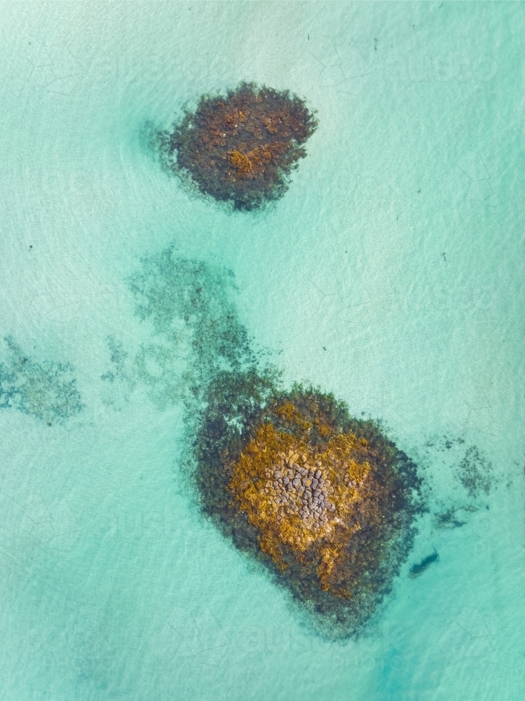 Image of Aerial view of small rocky reefs in turquoise blue water ...