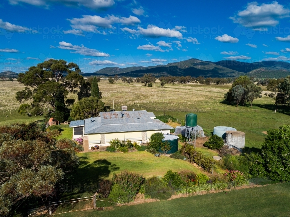 Image of Aerial view of sunlit house on farm with rain water tank ...