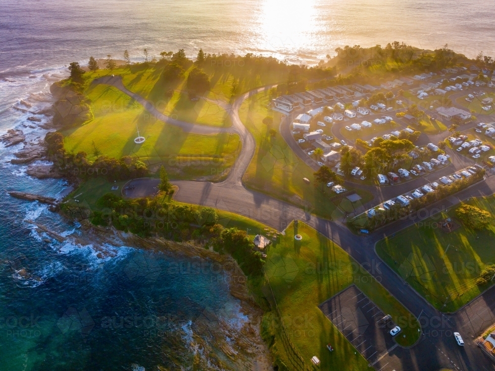 Image of Aerial view of sunrise over a caravan park on a coastal ...