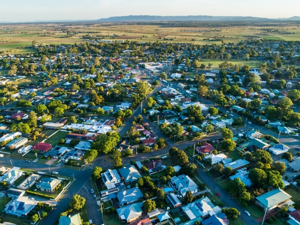 Image of Aerial view of sunset light over lush small aussie town with ...