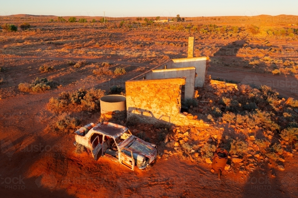 Image of Aerial view of the shell of an old house and car wreck ...