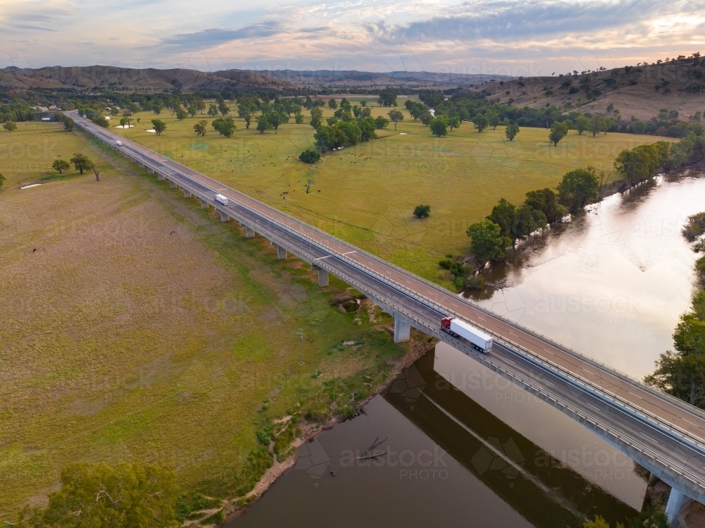 Image of Aerial view of traffic on freeway bridge over a wide river ...