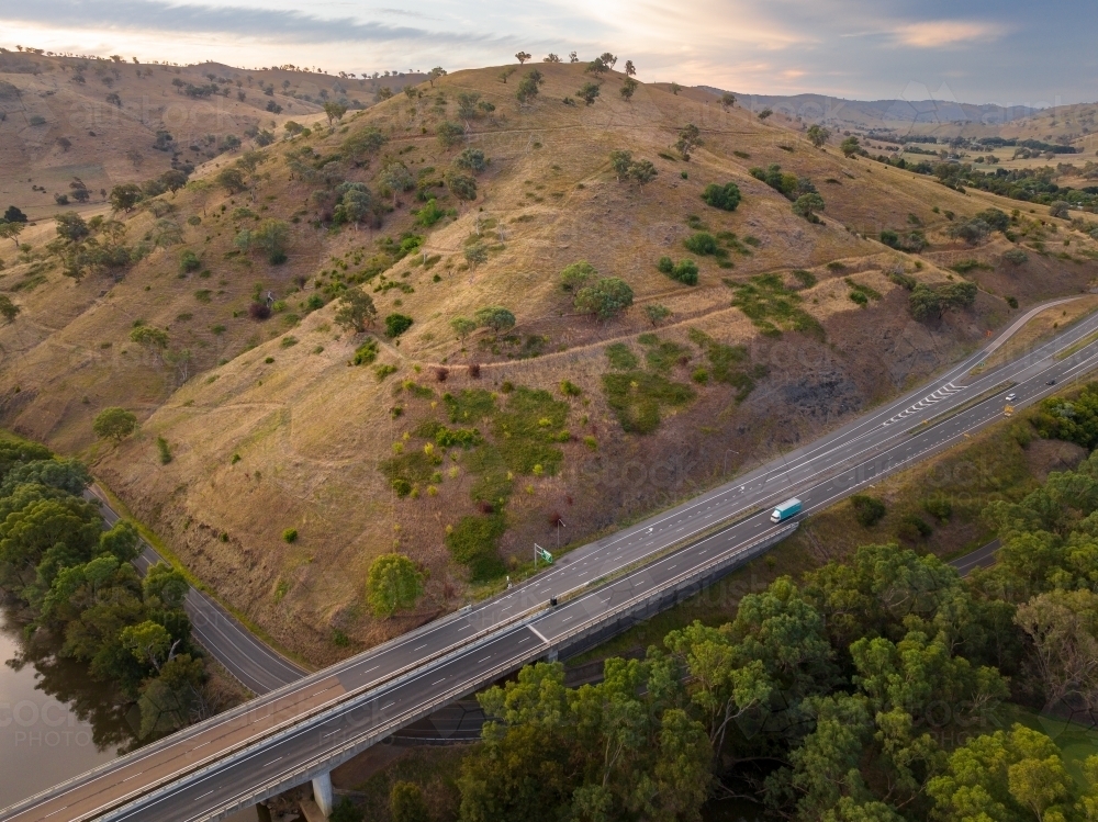 Image of Aerial view of traffic on freeway running around the side of a ...