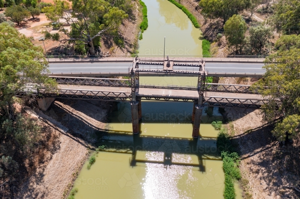 Image of Aerial view of two bridges crossing a dirty river lined with ...
