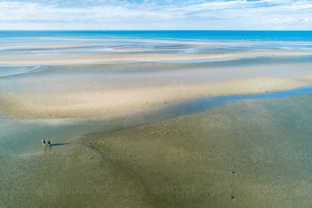 Image of Aerial view of two fishermen walking over tidal sand flats ...