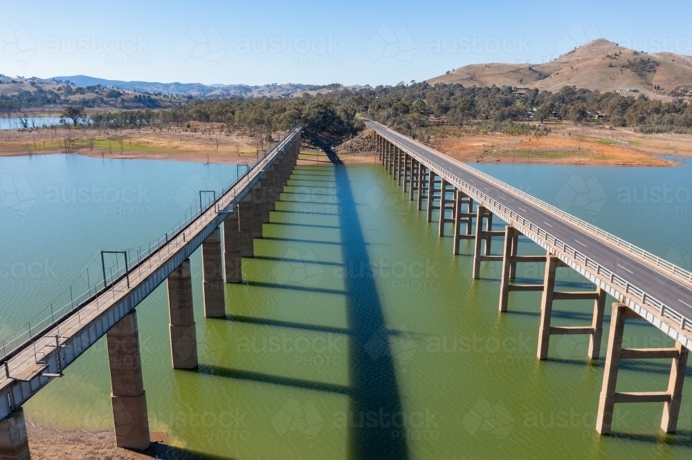 Image of Aerial view of two parallel bridges casting shadows over the ...