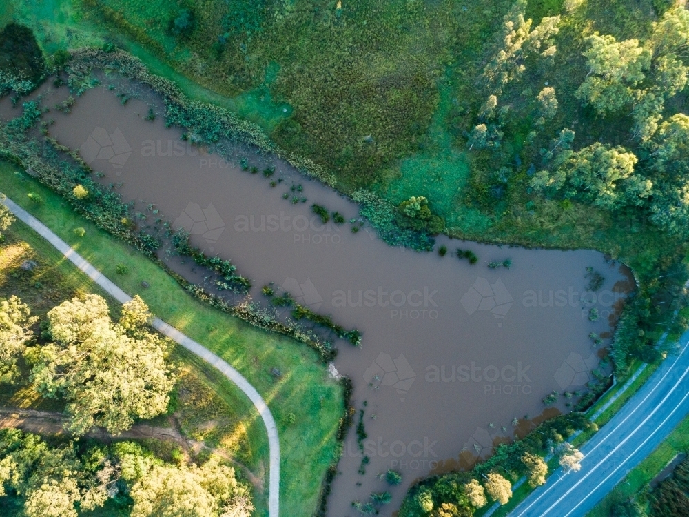 Image of aerial view of walkway beside flooding dam in park - Austockphoto