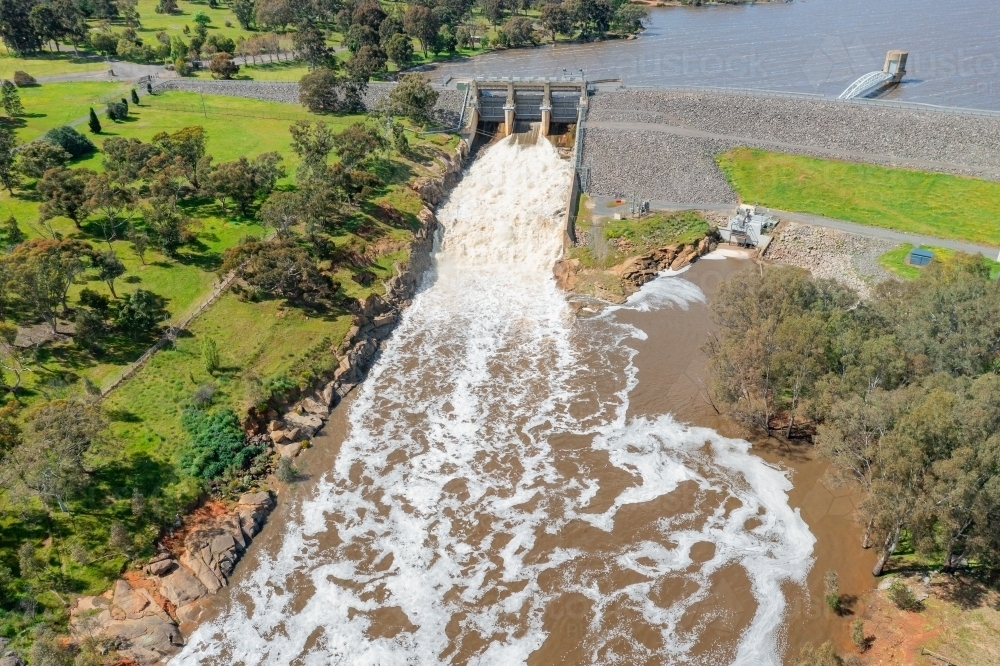 Image of Aerial view of water gushing from dam gates of a reservoir ...