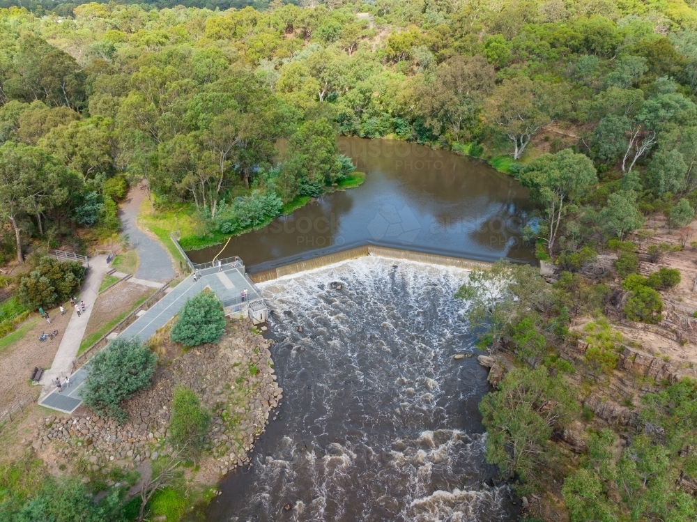 Image of Aerial view of water rushing over a waterfall and down a river ...