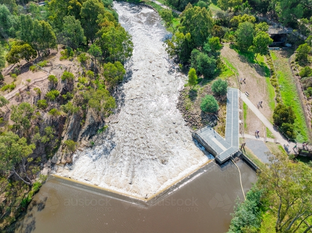 Image of Aerial view of water rushing over a waterfall and down a river ...