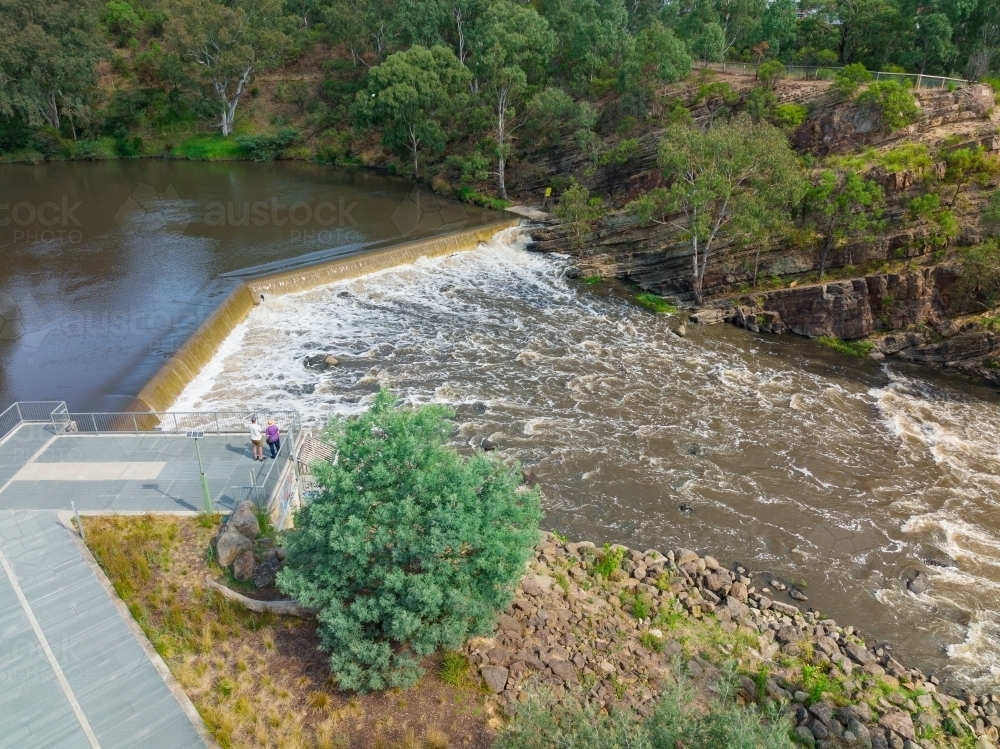 Image of Aerial view of water rushing over a waterfall and down a river ...