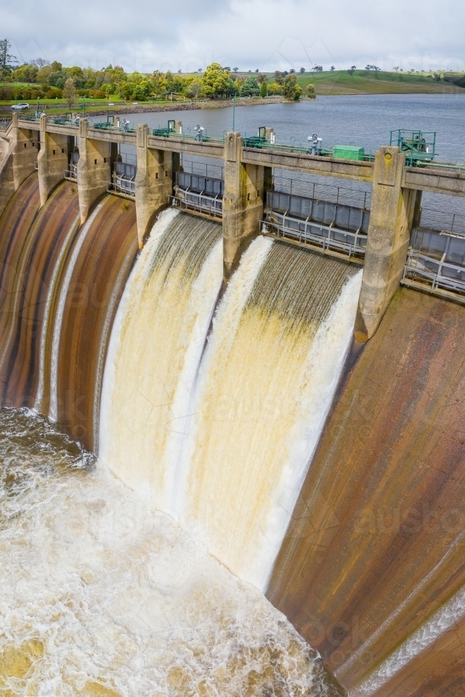 Image of Aerial view of water spilling over a weir from a reservoir ...