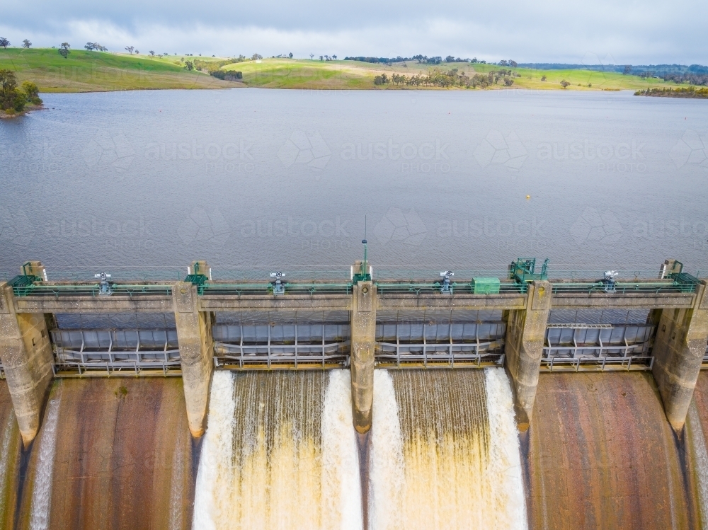 Image of Aerial view of water spilling over a weir from a reservoir ...
