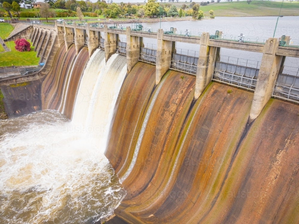 Image of Aerial view of water spilling over a weir from a reservoir ...