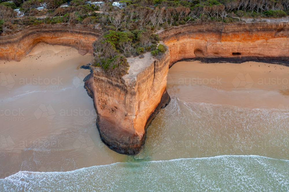 Image of Aerial view of waves on a beach below eroded coastal cliffs ...