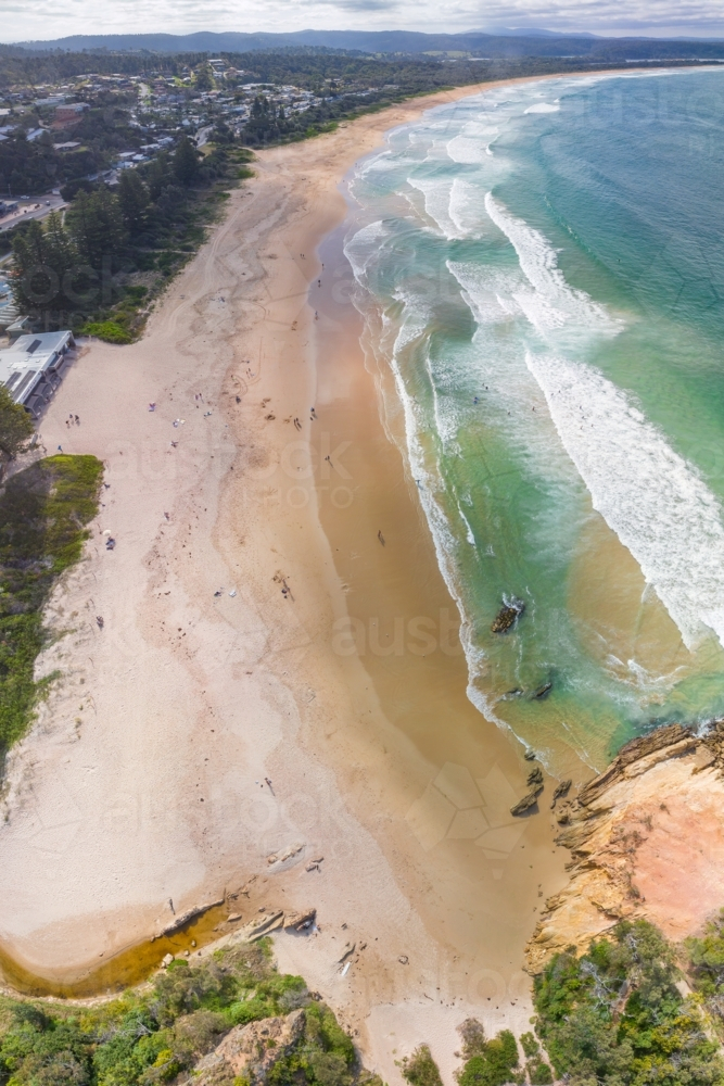 Image of Aerial view of waves rolling onto a long sandy beach ...