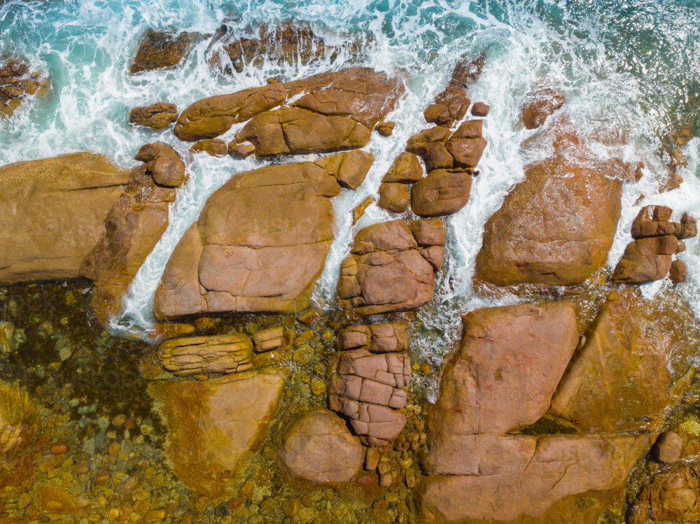 Image of Aerial view of waves washing into chutes in a rocky coastline ...